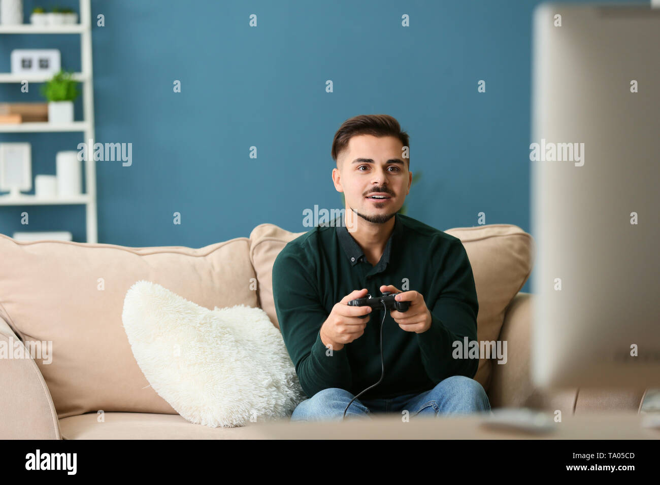 Young man playing video game at home Stock Photo - Alamy