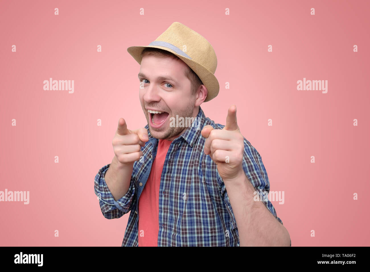 Excited young man pointing fingers at camera Stock Photo - Alamy