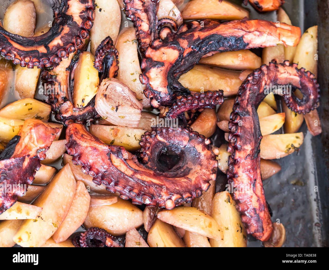 Baked octopus with potatoes in baking tray top view Stock Photo - Alamy