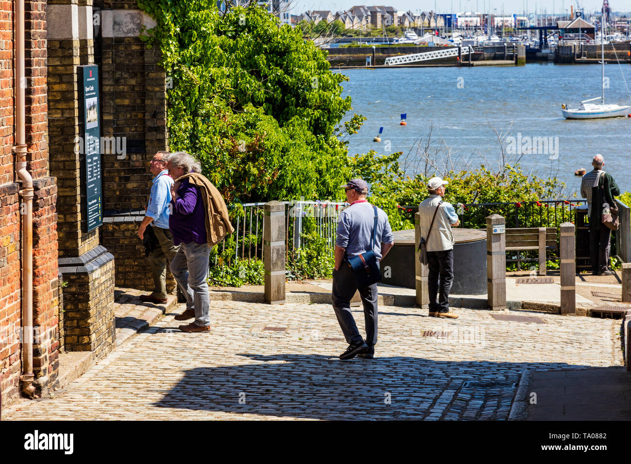 A group of male visitors enter Upnor Castle and look across the River ...