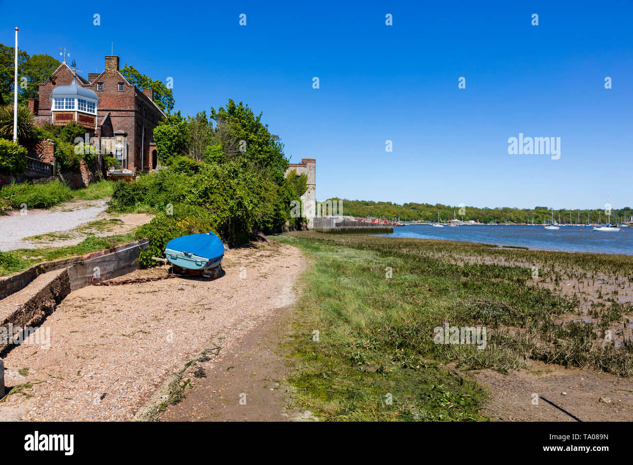 A blue wooden dinghy on the beach below Upnor Castle and an octagonal ...