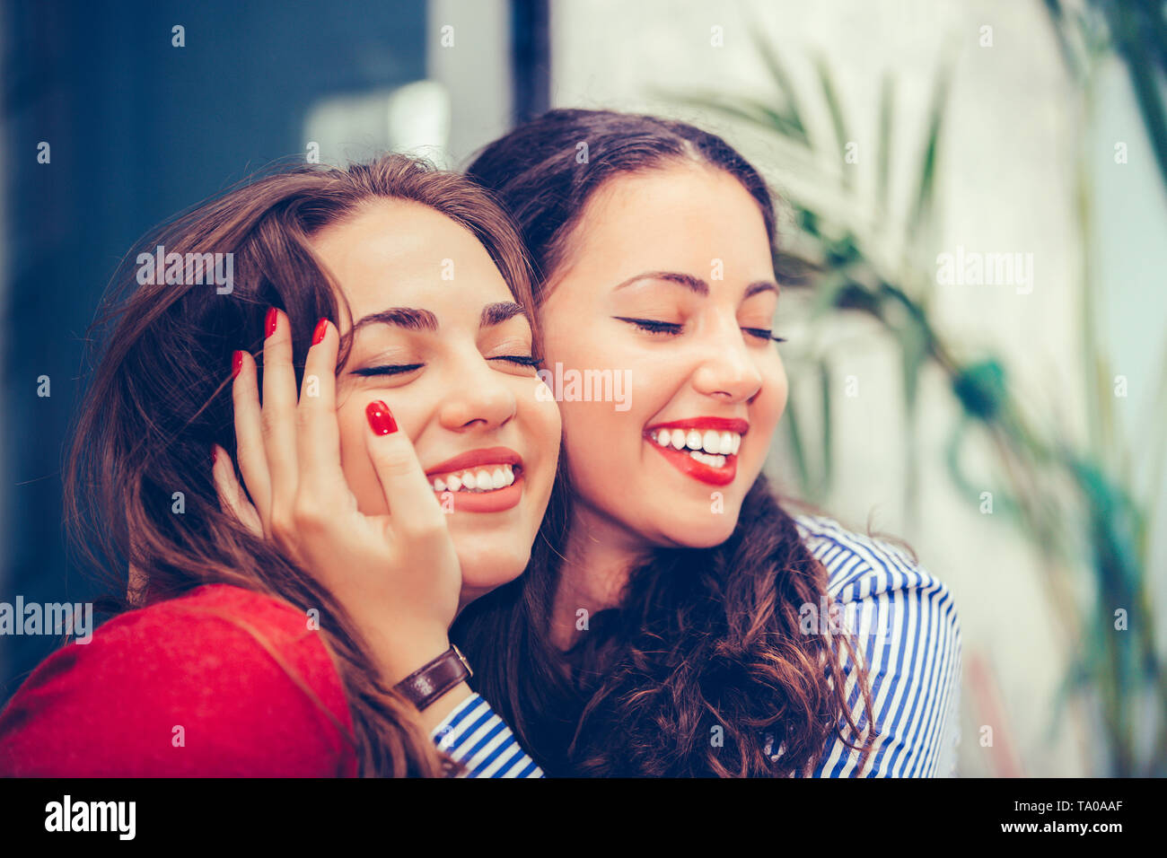 Happy lady hugging best friend, sitting in a cafe, having pleasant talk ...