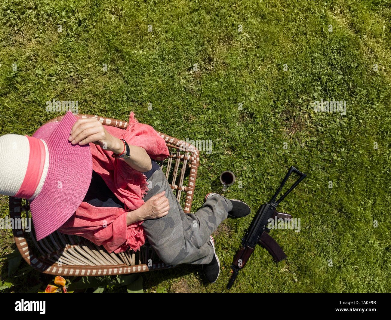 Birrd eyes view of a woman sitting on a lawn with a machine gun on the ...