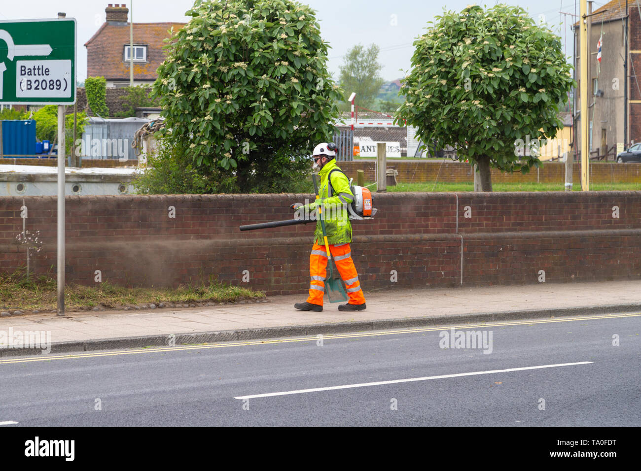 highway maintenance workman with a petrol leaf blower cleaner the walls ...