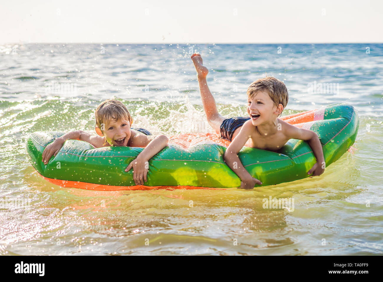 Children swim in the sea on an inflatable mattress and have fun Stock ...