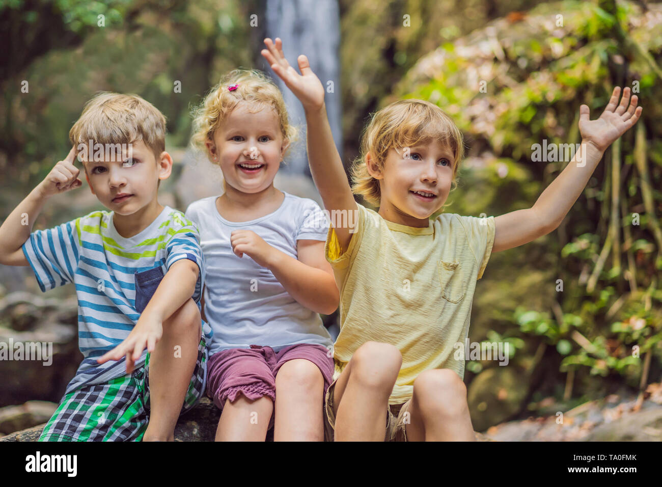 Children rest during a hike in the woods Stock Photo - Alamy
