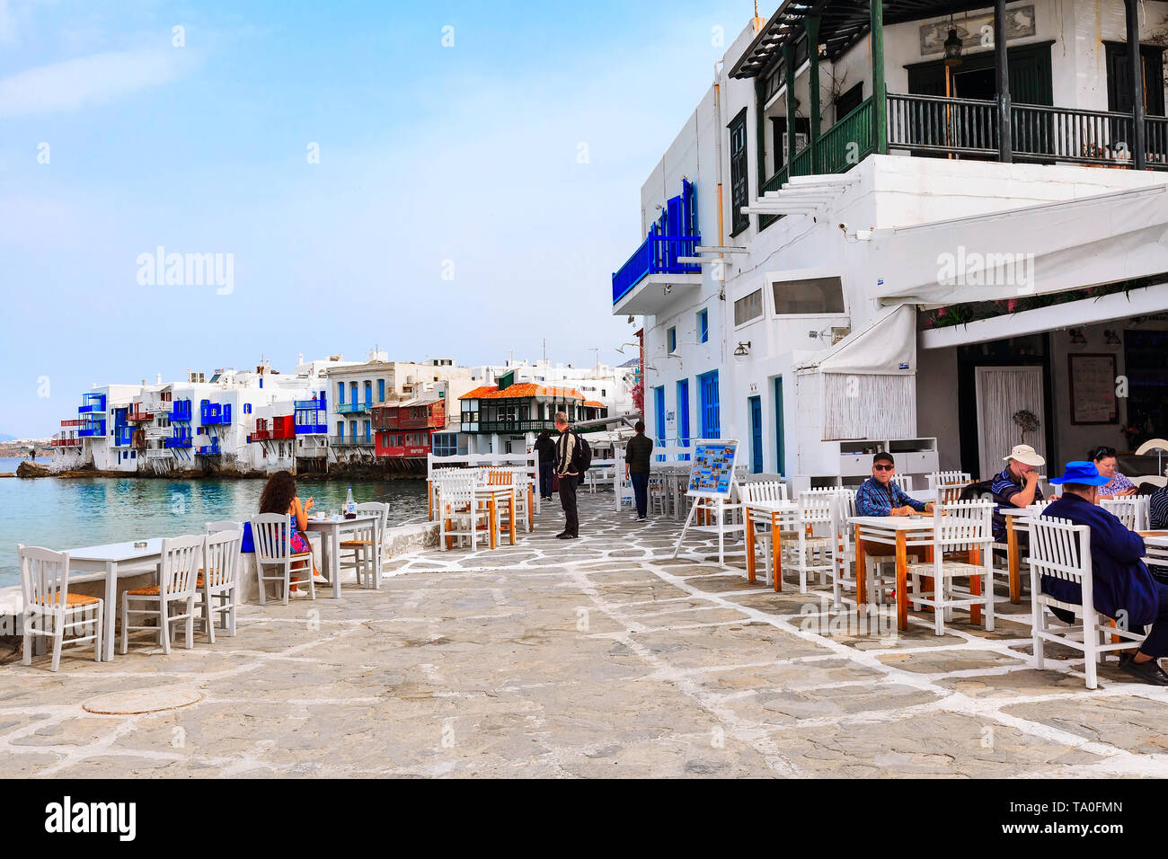 Mykonos, Greece - April 23, 2019: People, promenade with chairs and ...
