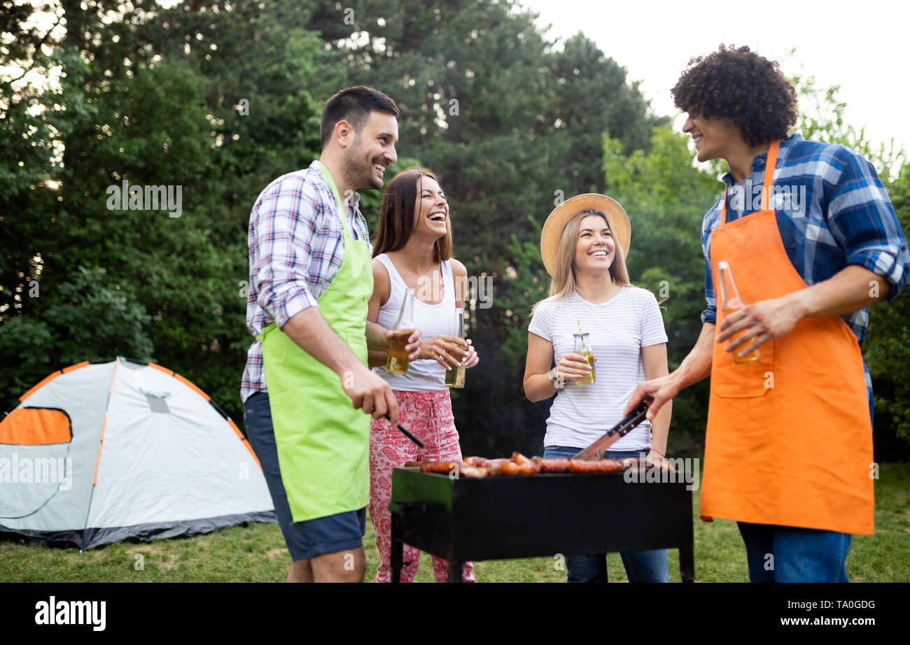 Happy friends enjoying barbecue and grill party outdoor Stock Photo - Alamy
