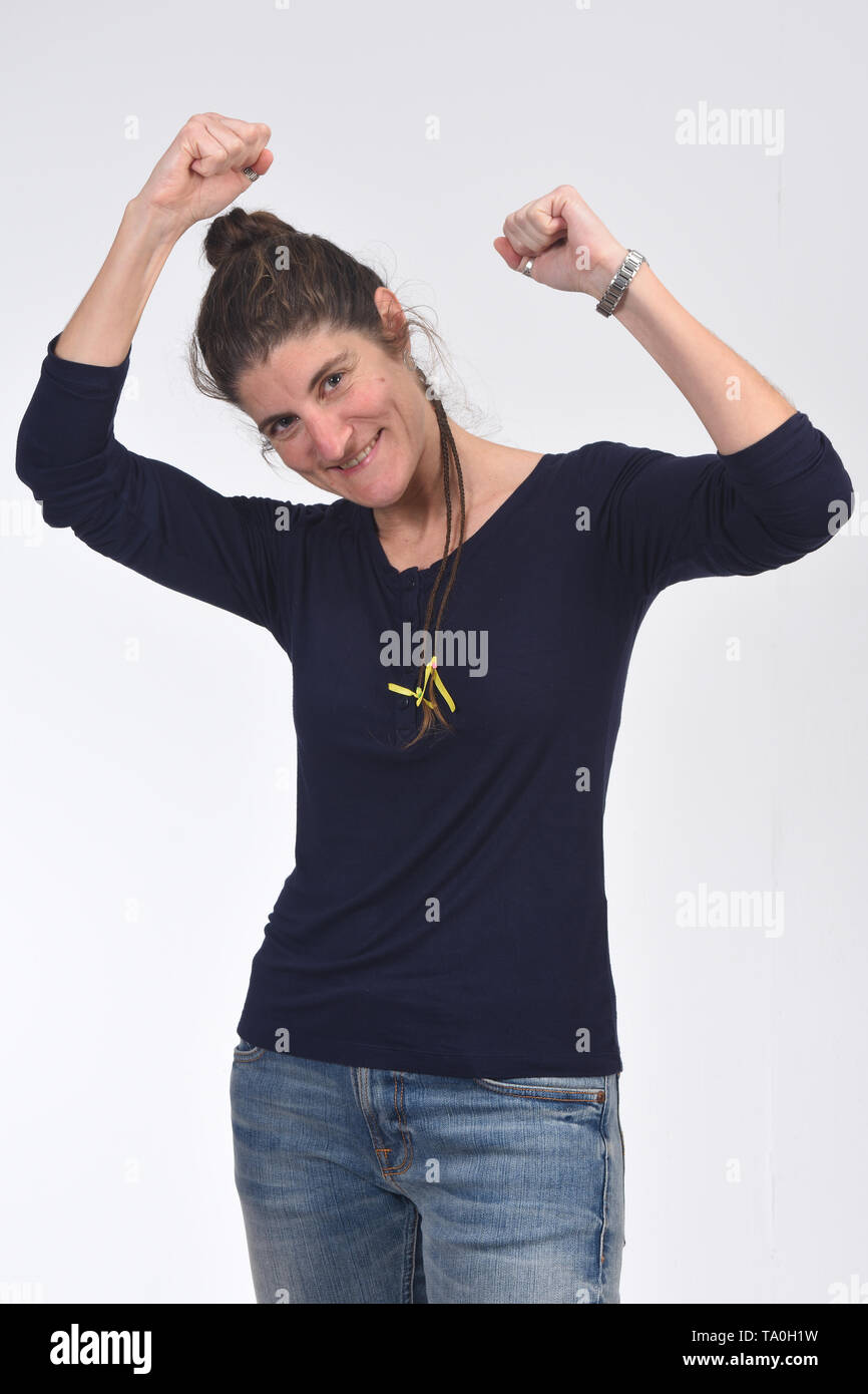 woman raising her arms and smiling in victory sign on white background ...