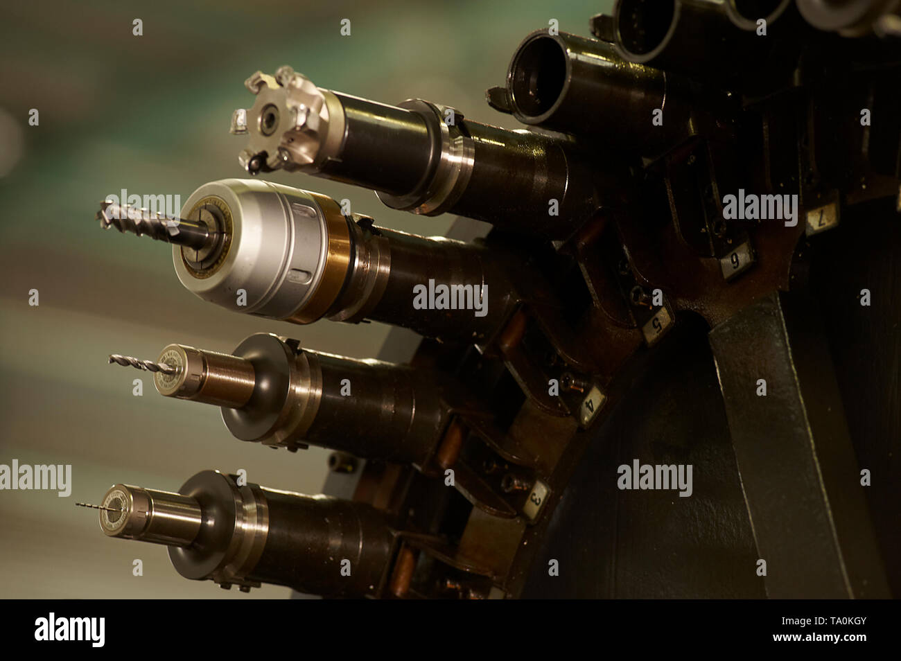 Close up of metal drills of different sizes on a rotating machine in a ...