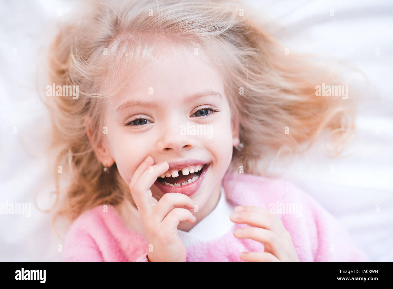 Laughing Baby Girl 4 5 Year Old Lying In Bed Closeup Looking At Camera laughing-baby-girl-4-5-year-old-lying-in-bed-closeup-looking-at-camera