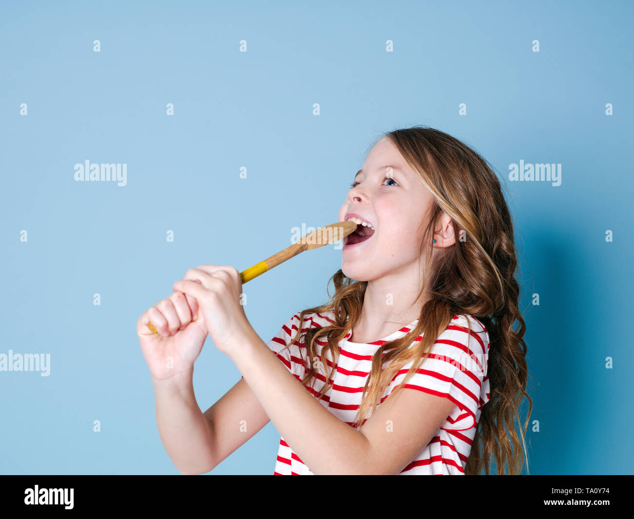 pretty cool and young girl uses cooking spoon as microphone and sings ...