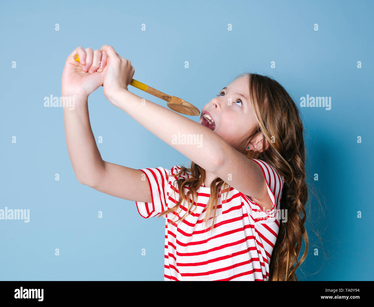 pretty cool and young girl uses cooking spoon as microphone and sings ...