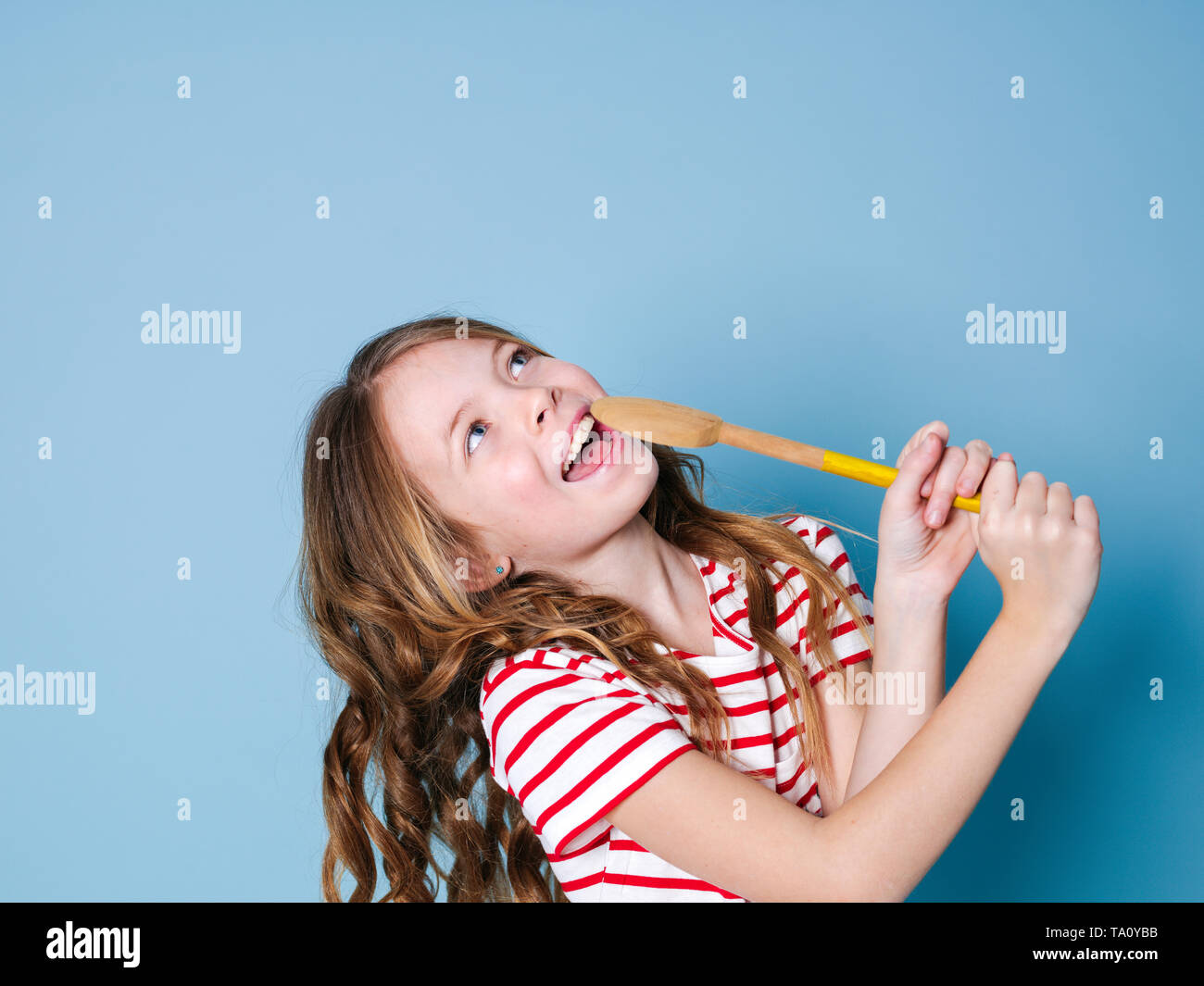pretty cool and young girl uses cooking spoon as microphone and sings ...