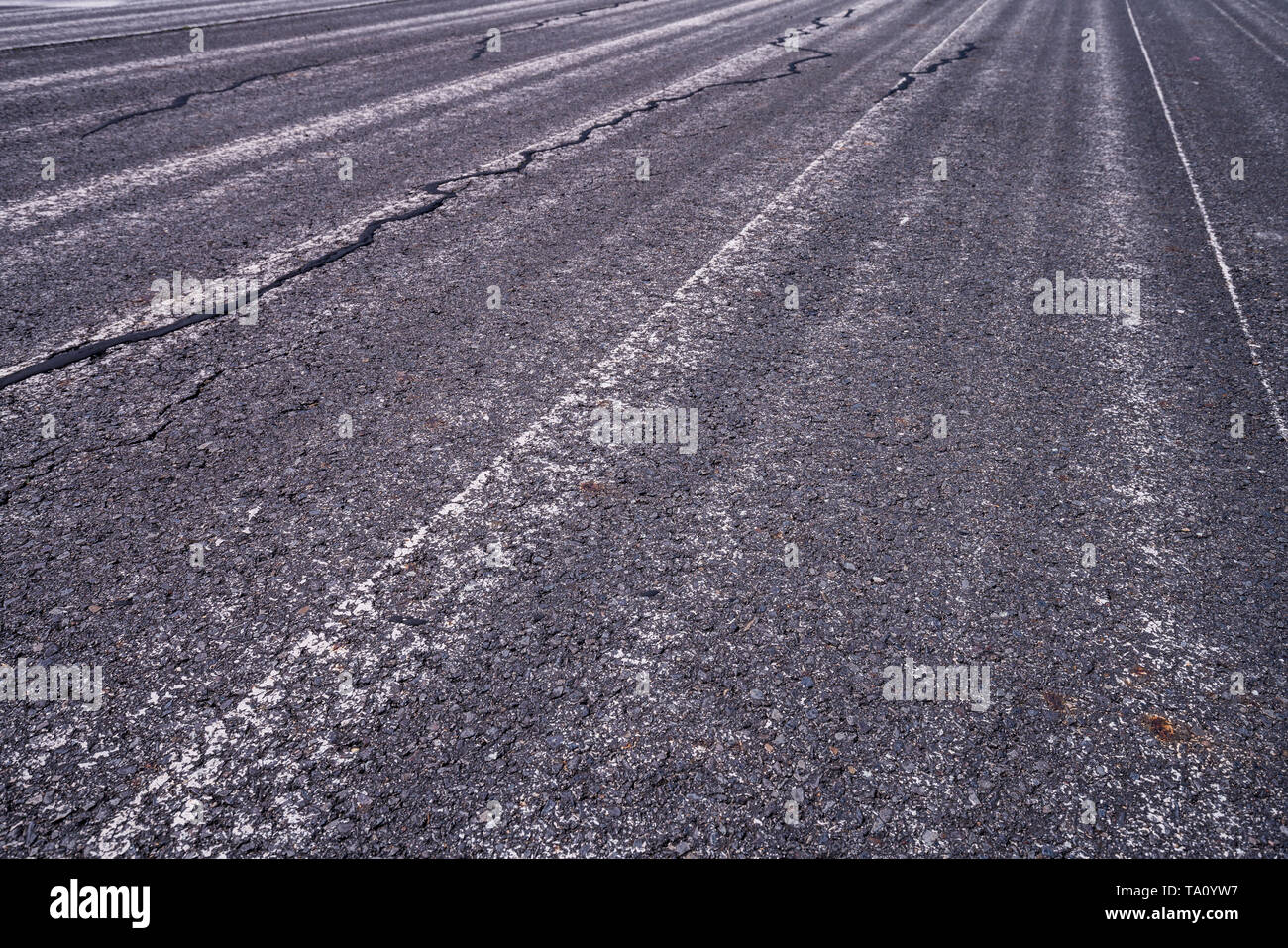 faded white road markings on a street for backgrounds Stock Photo - Alamy