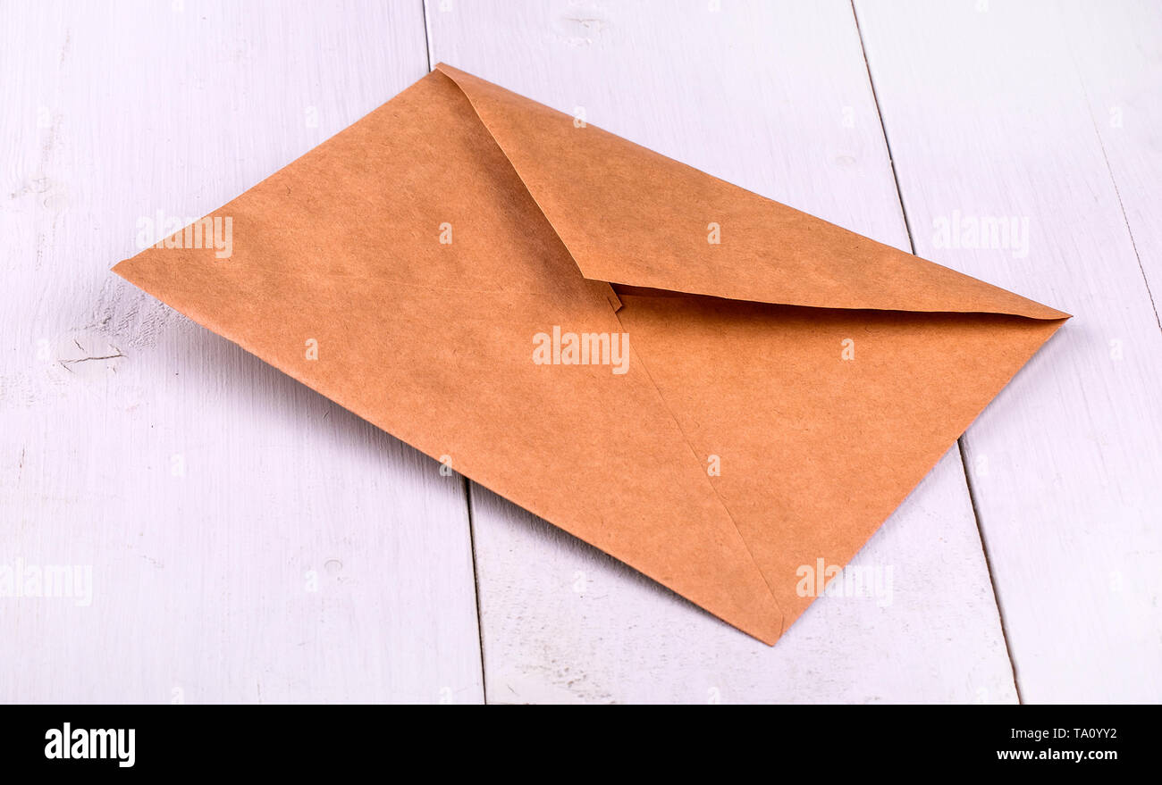 Paper envelope on a white wooden table Stock Photo - Alamy