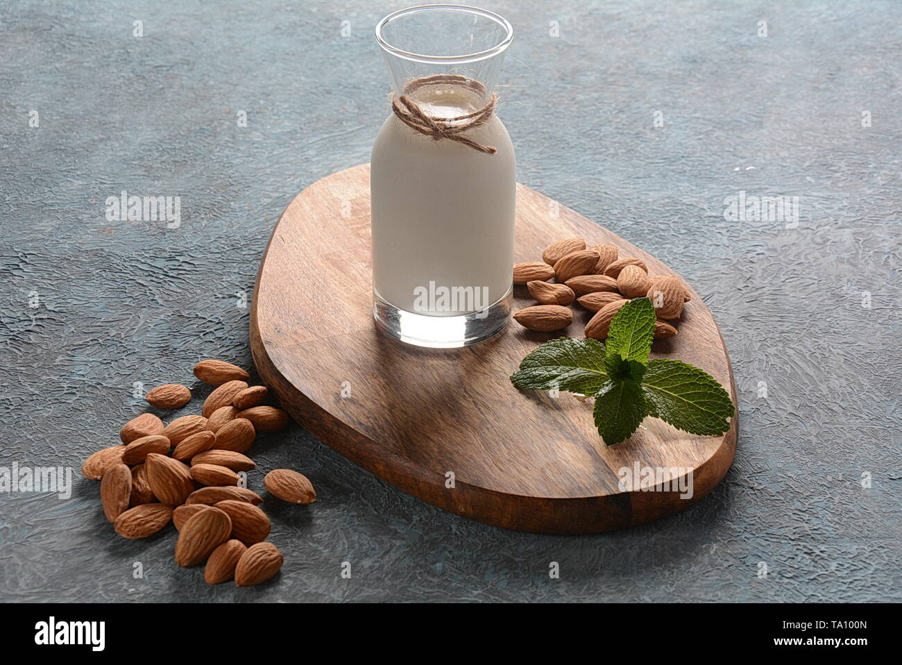 Almond milk in glass bottles with almonds on background. Vegan diary ...