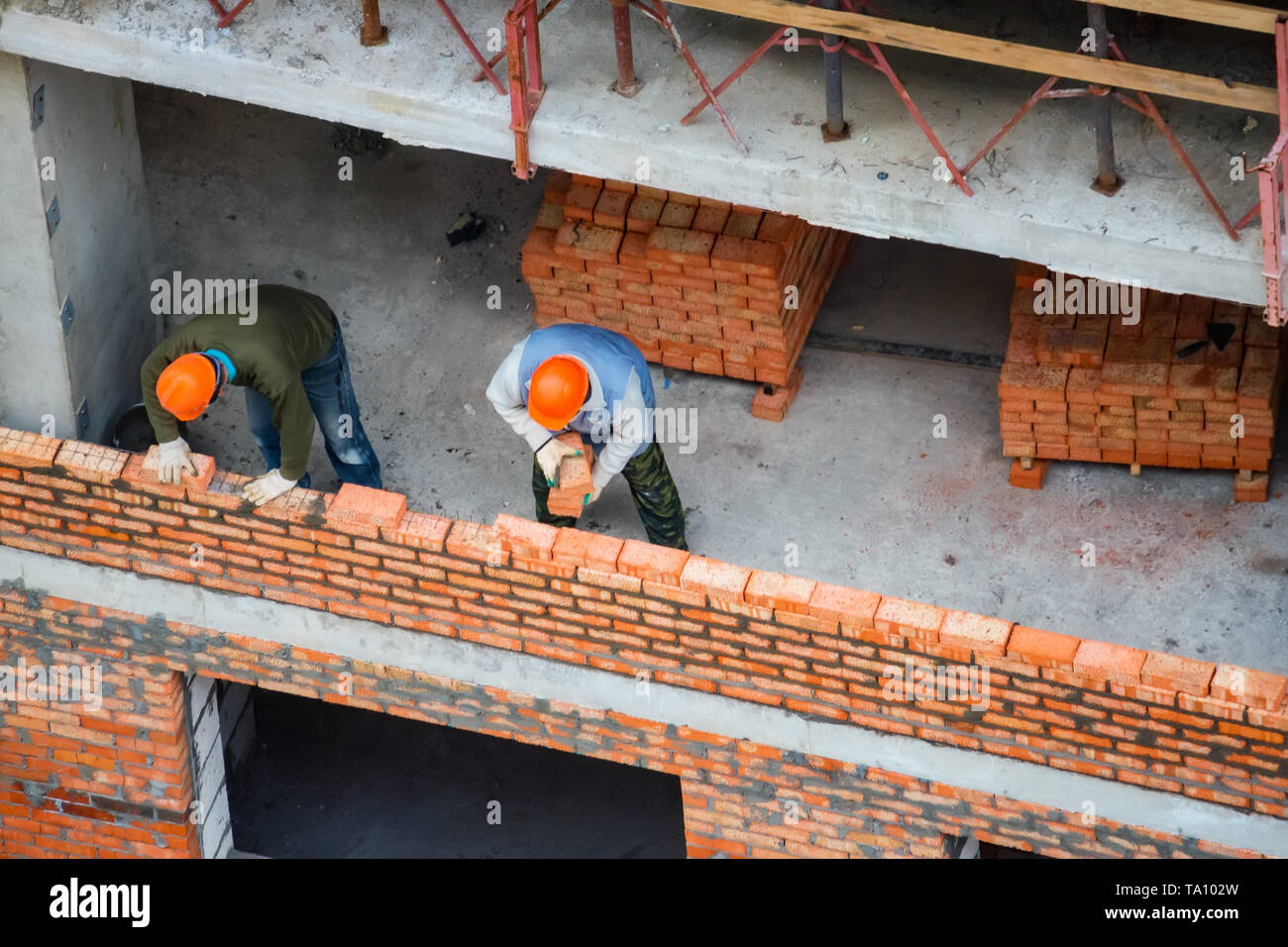 Workers making brick wall at a new building construction site Stock ...