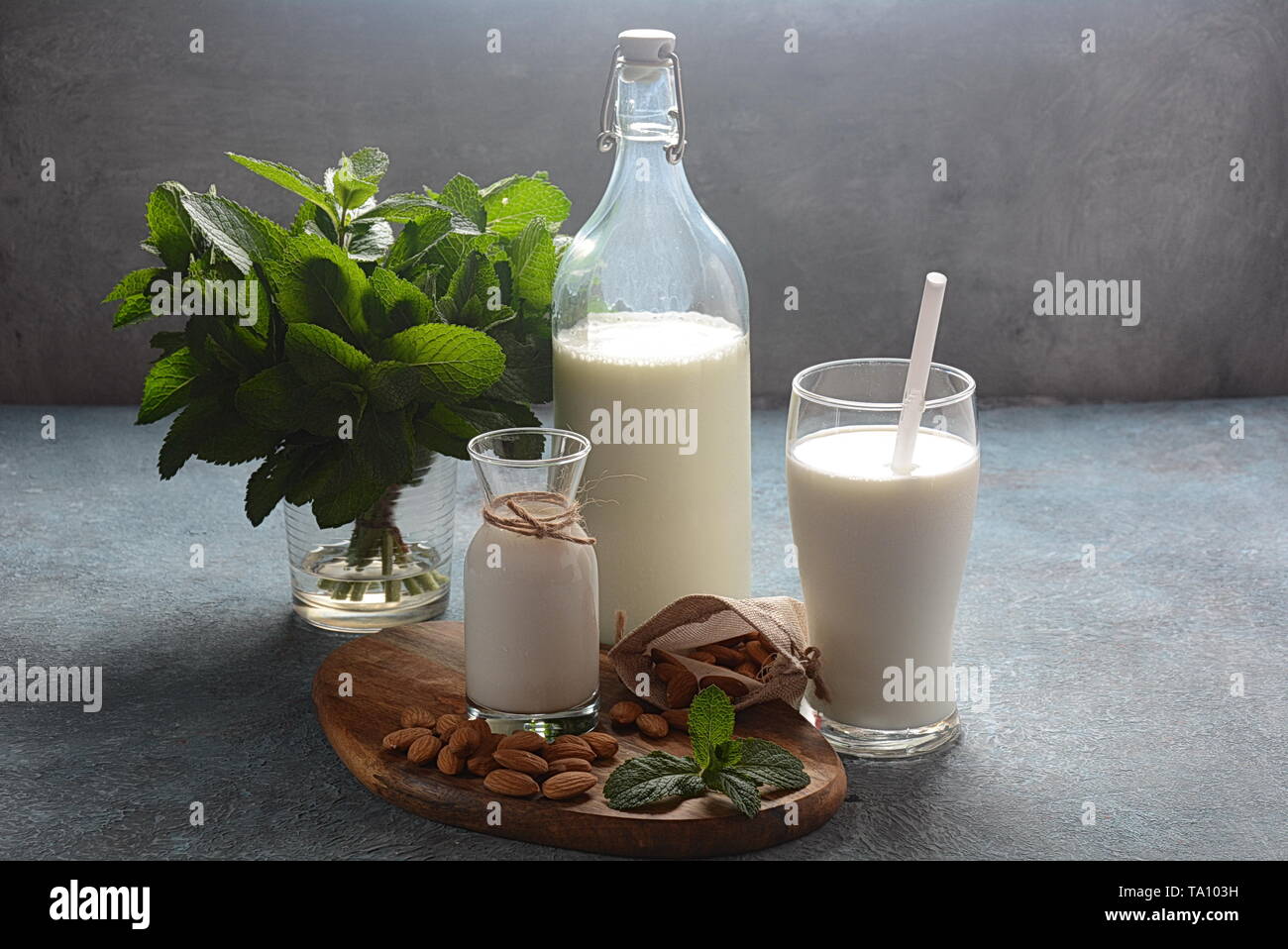 Almond milk in glass bottles with almonds on background. Vegan diary ...
