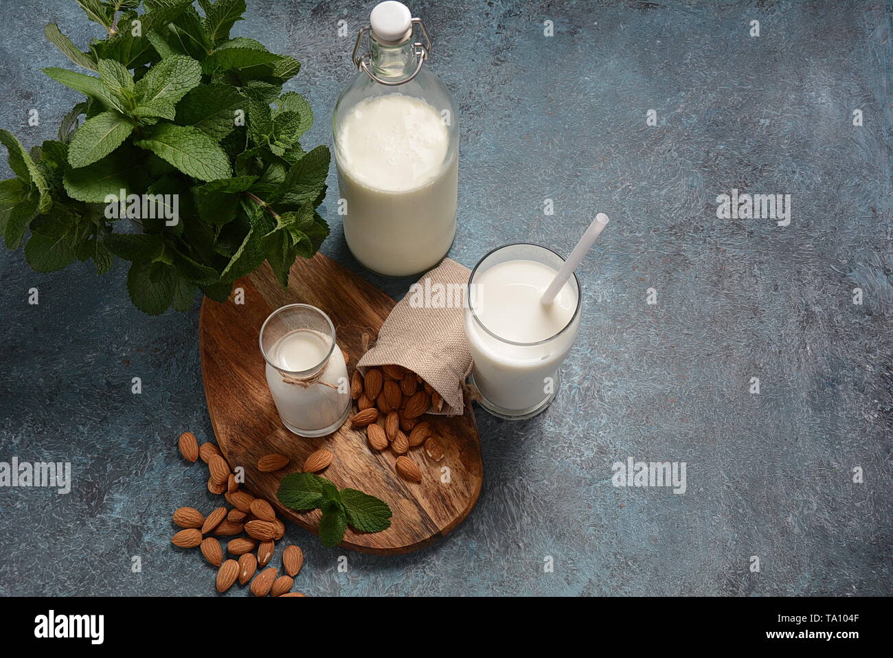 Almond milk in glass bottles with almonds on background. Vegan diary ...