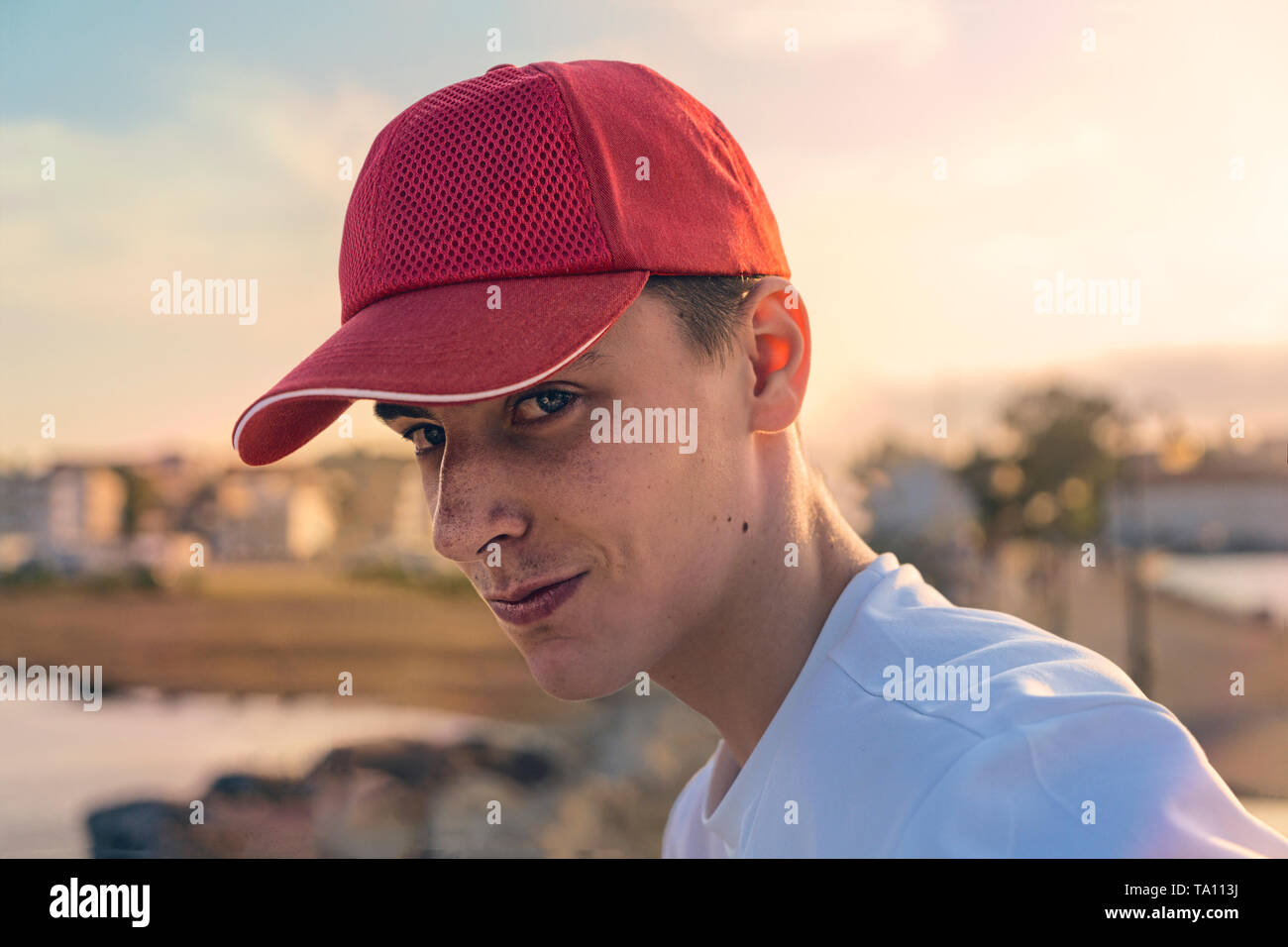 portrait of a smiling young man with red baseball cap Stock Photo - Alamy