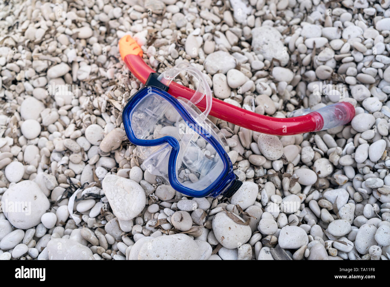 Diving mask lies on a white stone beach Stock Photo - Alamy