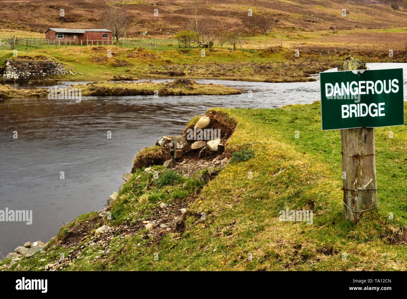 A warning sign showing where a bridge used to cross a river Stock Photo ...