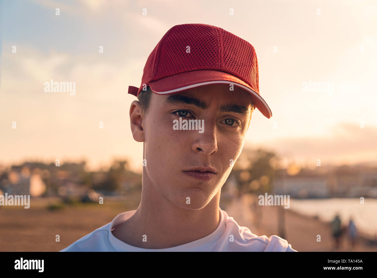 portrait of a smiling young man with red baseball cap Stock Photo - Alamy