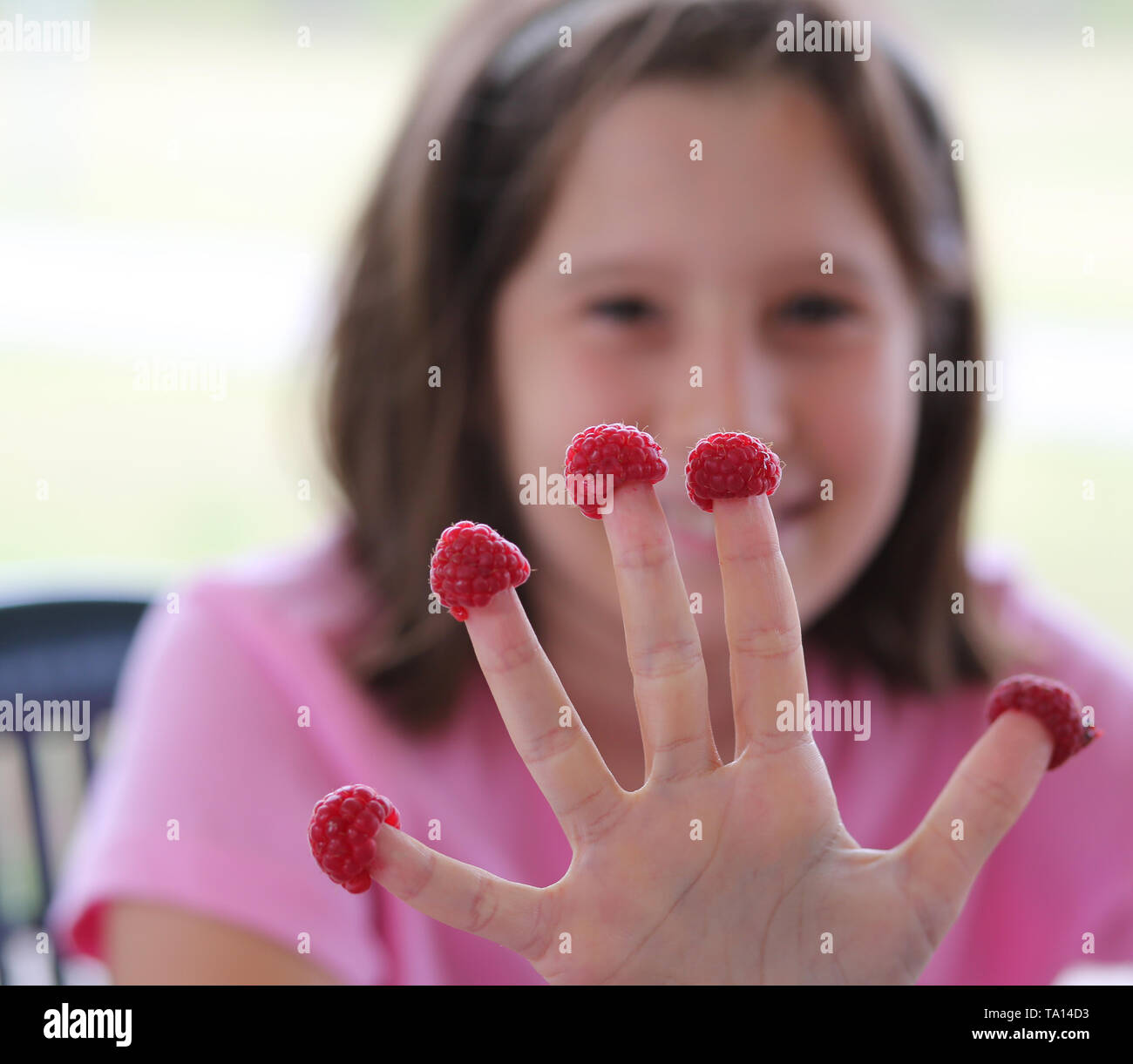 little girl with five raspberries on the hand Stock Photo - Alamy