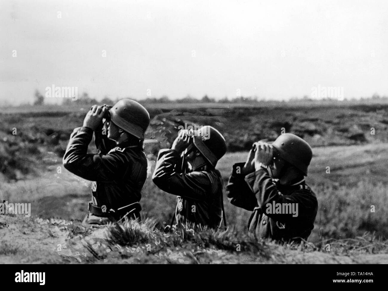 Infantrymen observe the Luftwaffe with binoculars during their ...