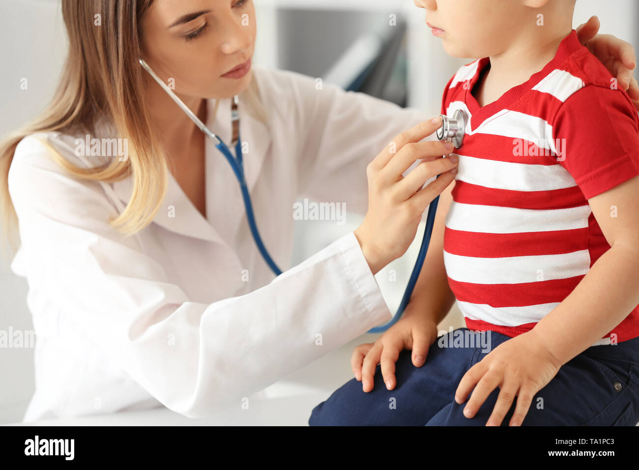 Female doctor working with cute little boy in clinic Stock Photo - Alamy