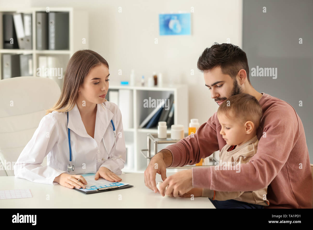 Young father with his little son visiting doctor in clinic Stock Photo ...