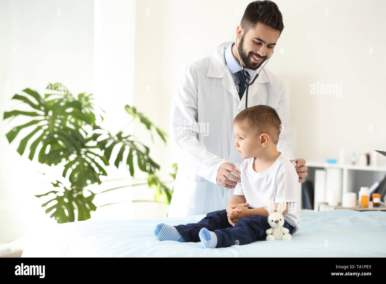 Male doctor working with cute little boy in clinic Stock Photo - Alamy