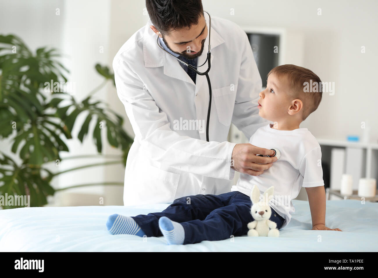 Male doctor working with cute little boy in clinic Stock Photo - Alamy