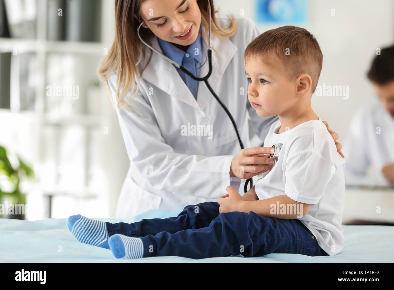 Female doctor working with cute little boy in clinic Stock Photo - Alamy