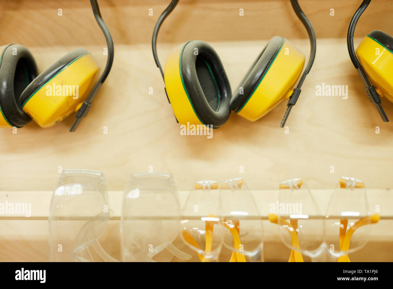 Background image of several earmuffs and face guards on wooden safety ...