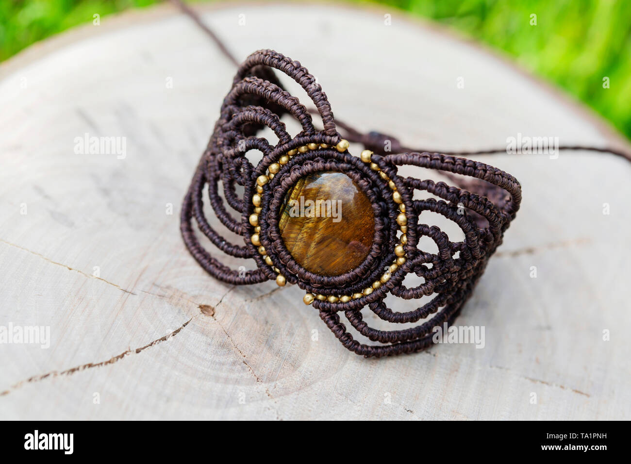 Macrame bracelet with natural mineral gemstone on natural wooden ...