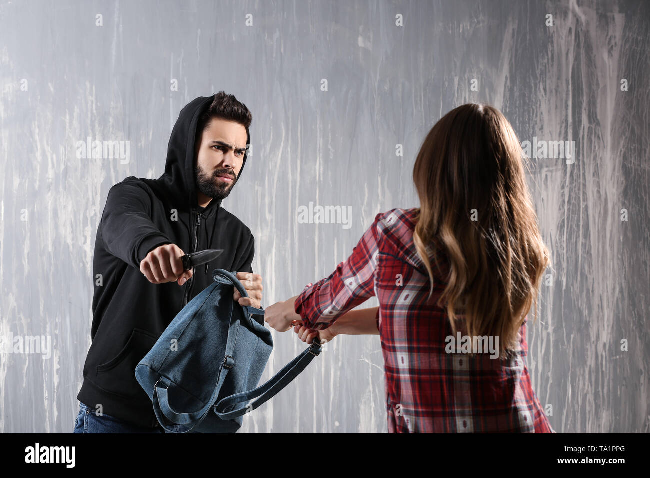 Male thief stealing bag from young woman against grunge background ...