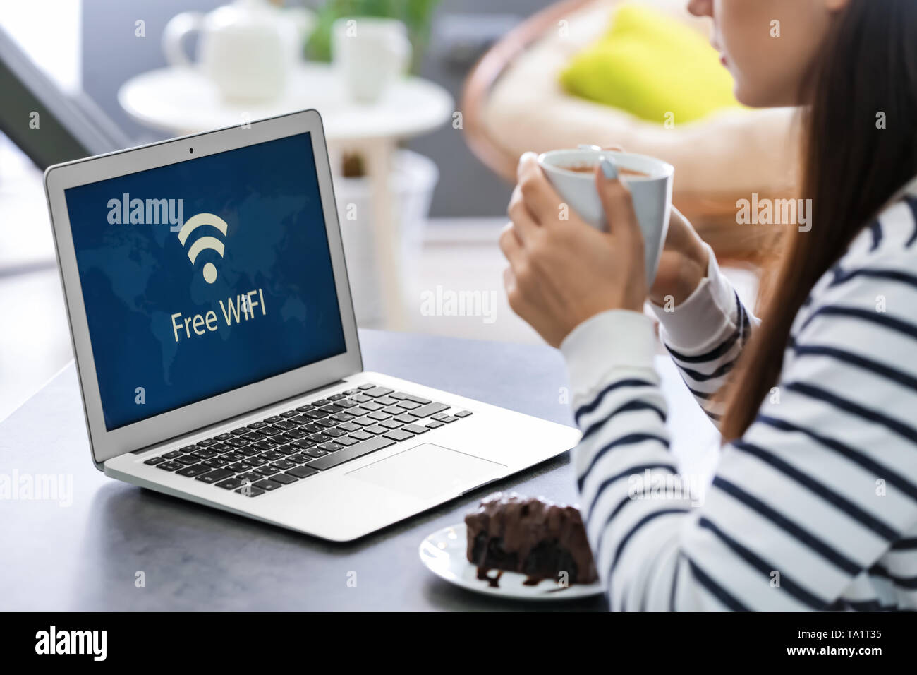 Young woman with laptop using wifi in cafe Stock Photo - Alamy