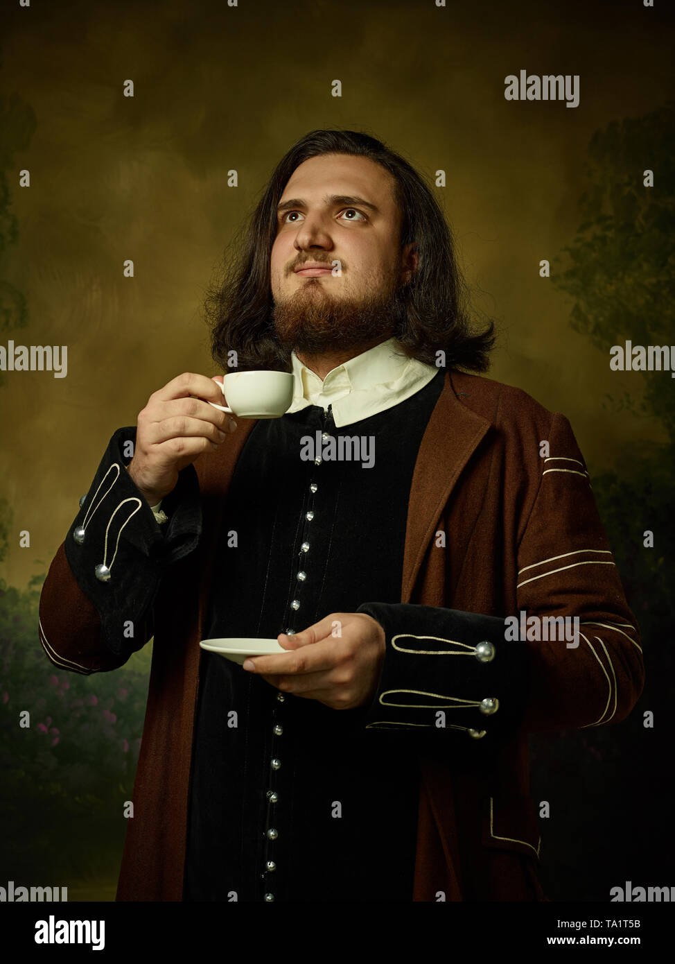 Young man as a medieval knight on dark studio background. Portrait in ...