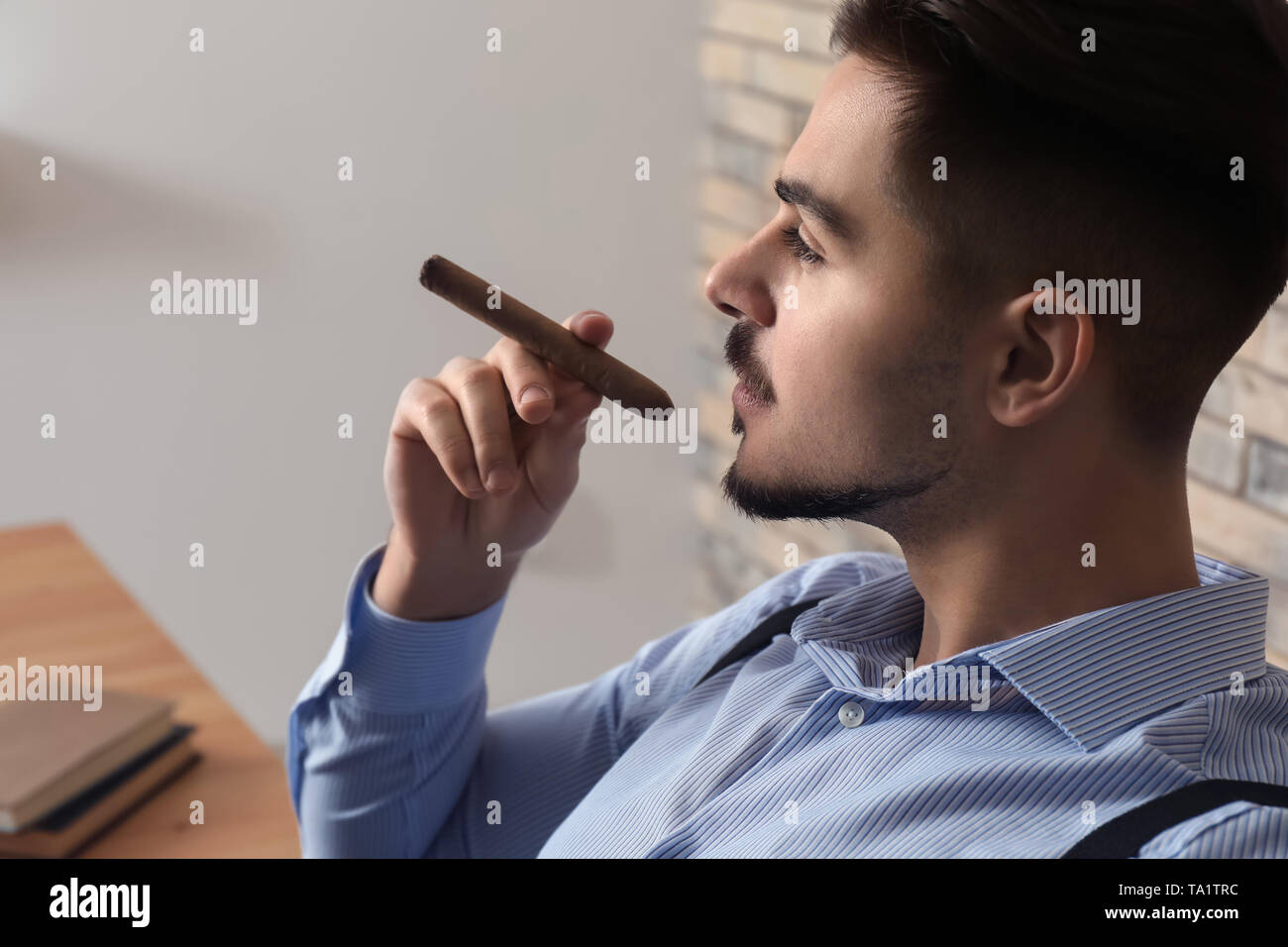 Stylish handsome man smoking cigar at home Stock Photo - Alamy