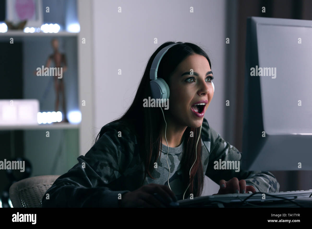 Emotional young woman playing computer game at home Stock Photo - Alamy
