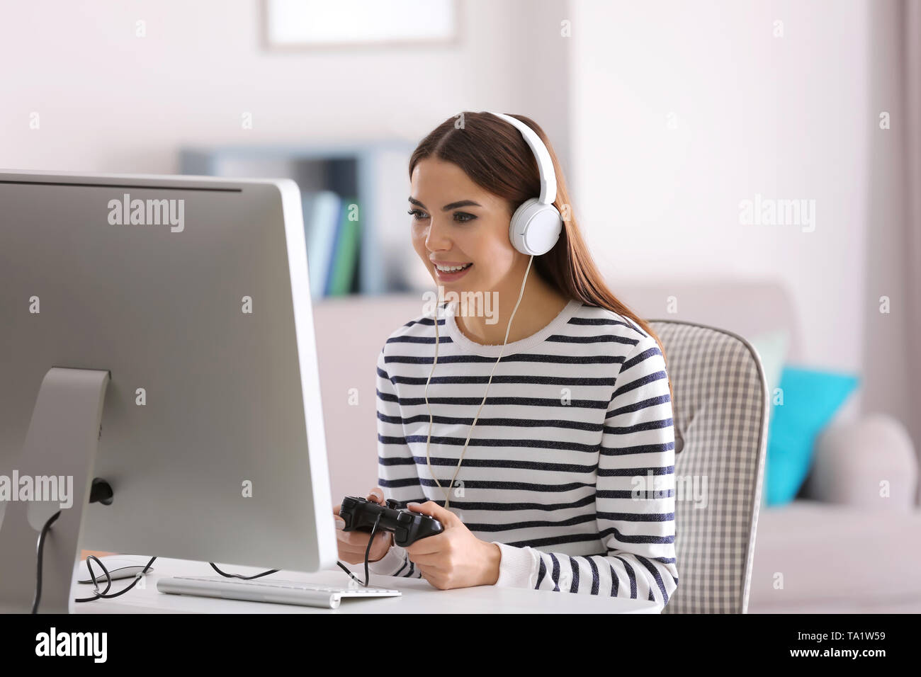 Beautiful young woman playing computer game at home Stock Photo - Alamy