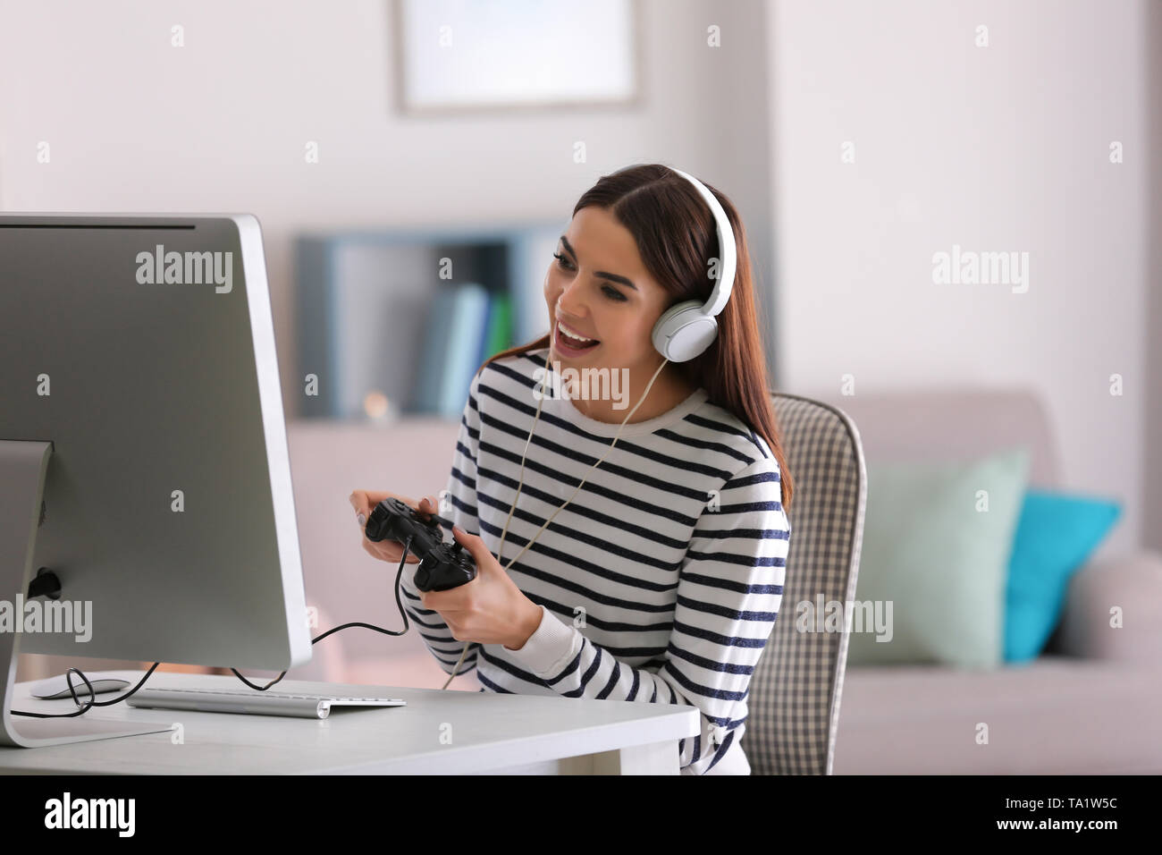 Emotional young woman playing computer game at home Stock Photo - Alamy