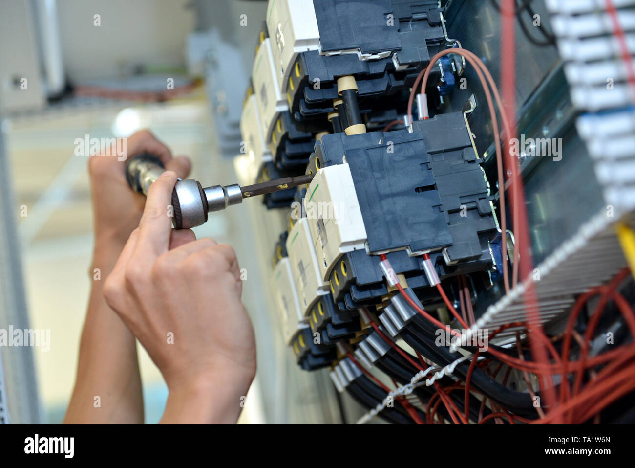 The electrician is connecting the electric cable wire. Engineer ...