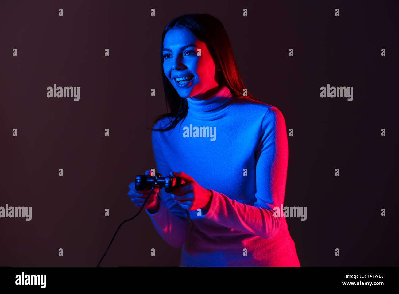 Beautiful happy woman playing computer game in darkness Stock Photo - Alamy