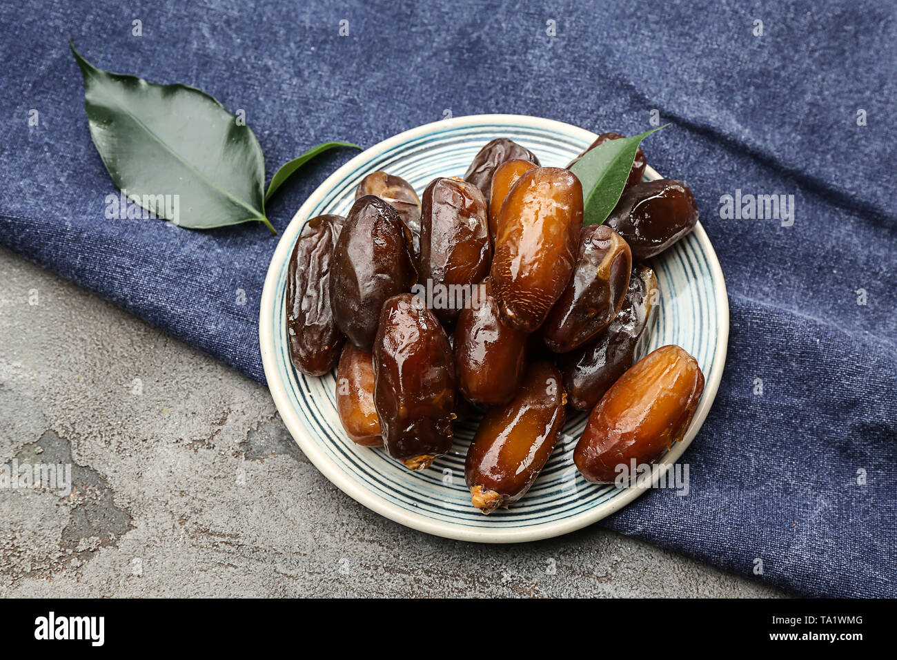 Plate with sweet dried dates on table Stock Photo - Alamy