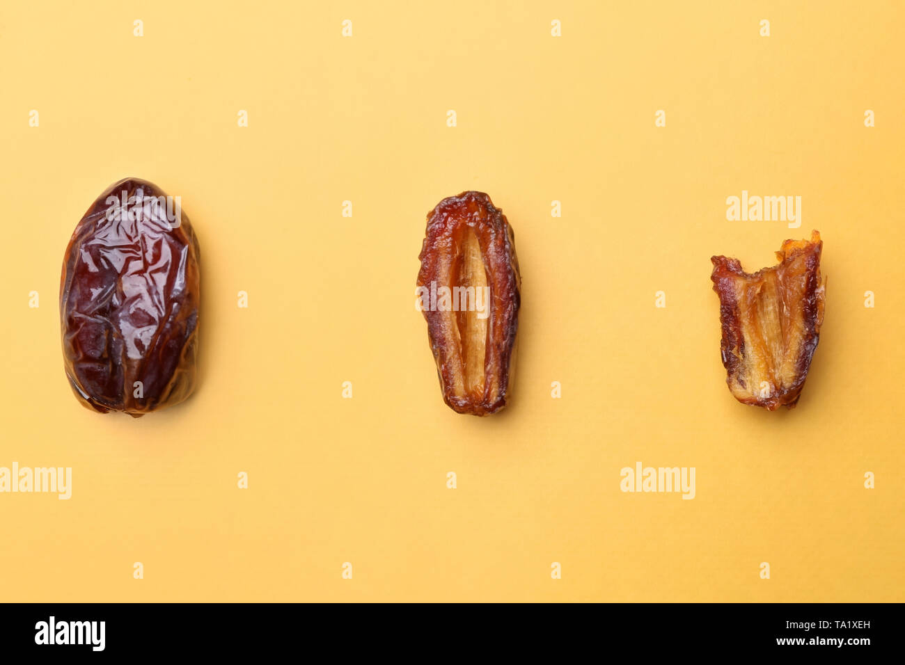 Whole and cut dates on color background Stock Photo - Alamy