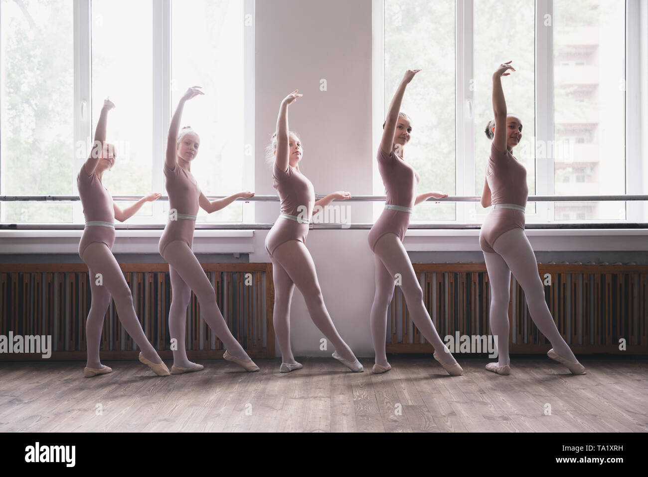 Young graceful female ballet dancers dancing at training studio. Beauty ...