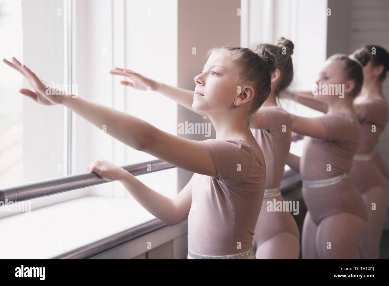 Young graceful female ballet dancers dancing at training studio. Beauty ...